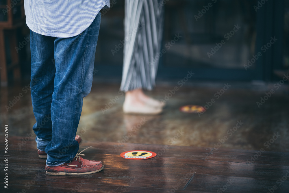 red round sign printed on ground at the font of cafe., People wearing ...
