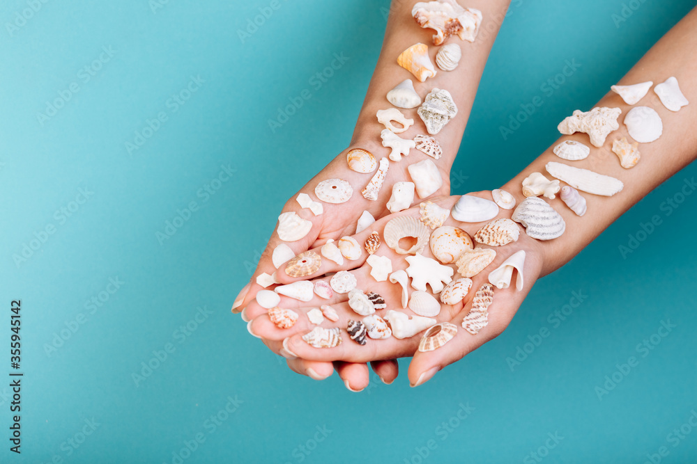 Macro of hand holding different kinds of seashells, corals in front of ...