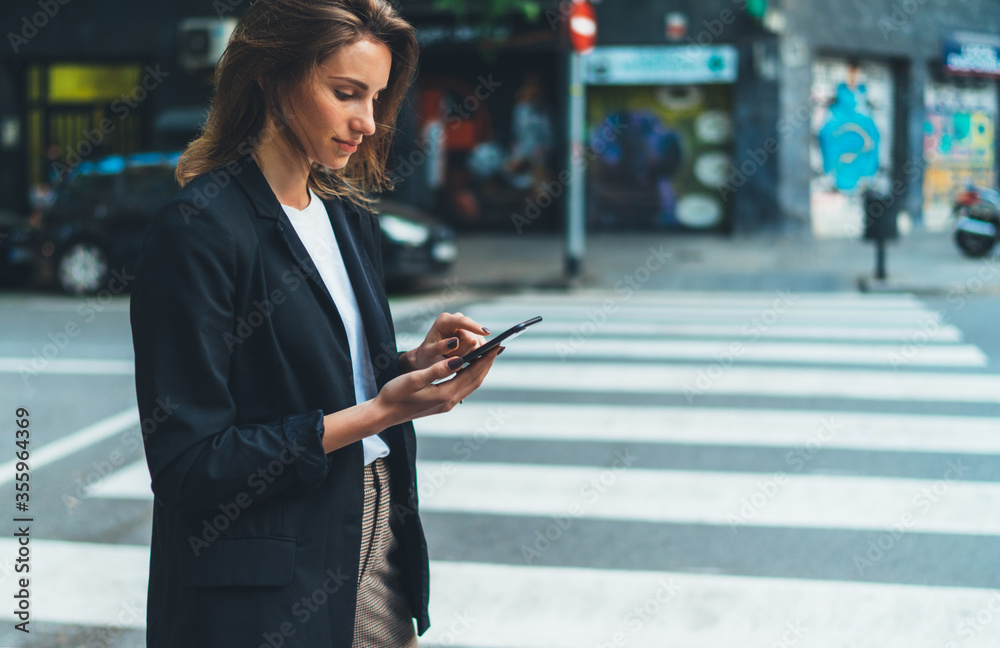 Foto de Woman using cellphone and crossing street, young hipster girl ...