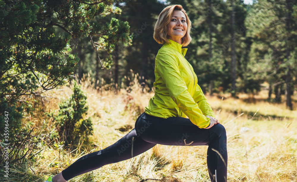 Fun girl exercising outdoors in green forest, activity with stretch ...