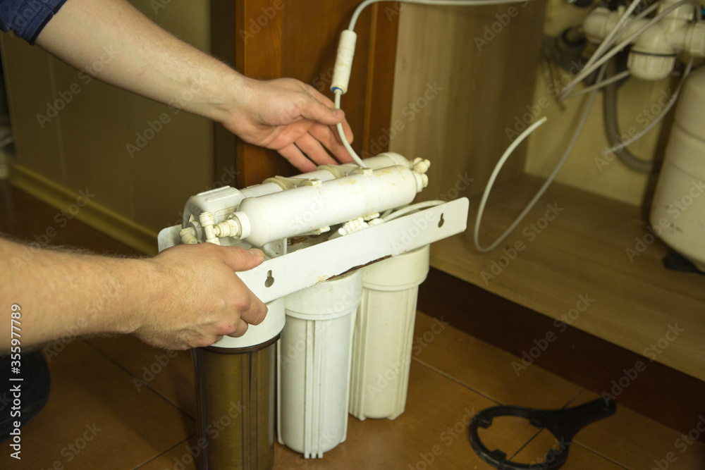 The master replaces dirty filters in the home water purification system ...