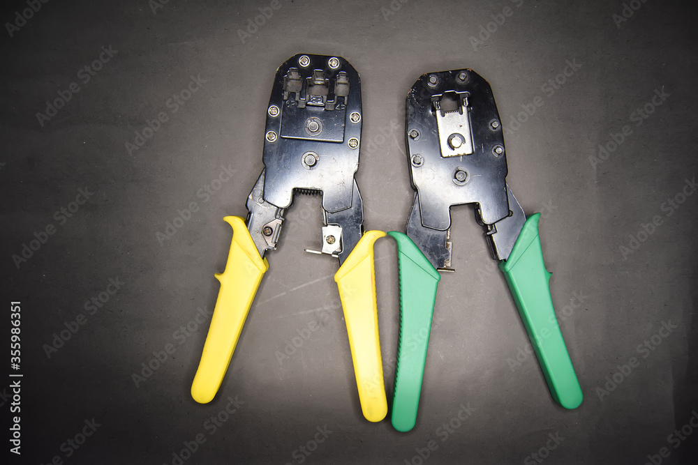 Yellow and green adjustable wire stripper isolated on a black ...