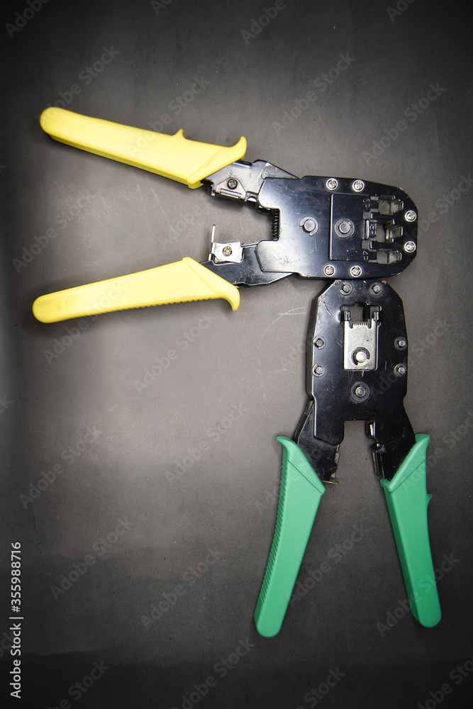 Yellow and green adjustable wire stripper joining head to head isolated ...