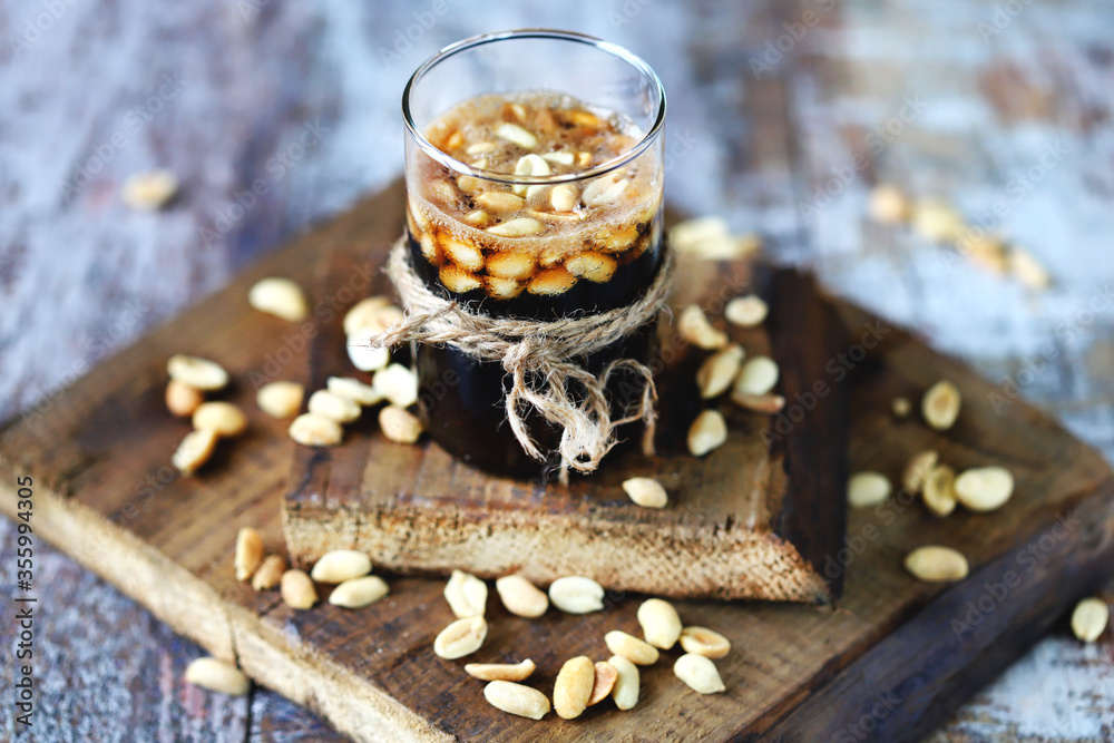 Selective focus. A glass of coca cola and peanuts. Salted peanuts in a ...