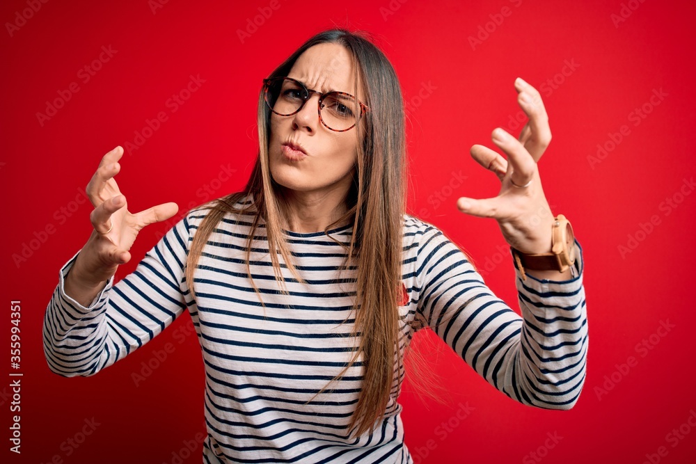 Young beautiful blonde woman with blue eyes wearing glasses standing ...