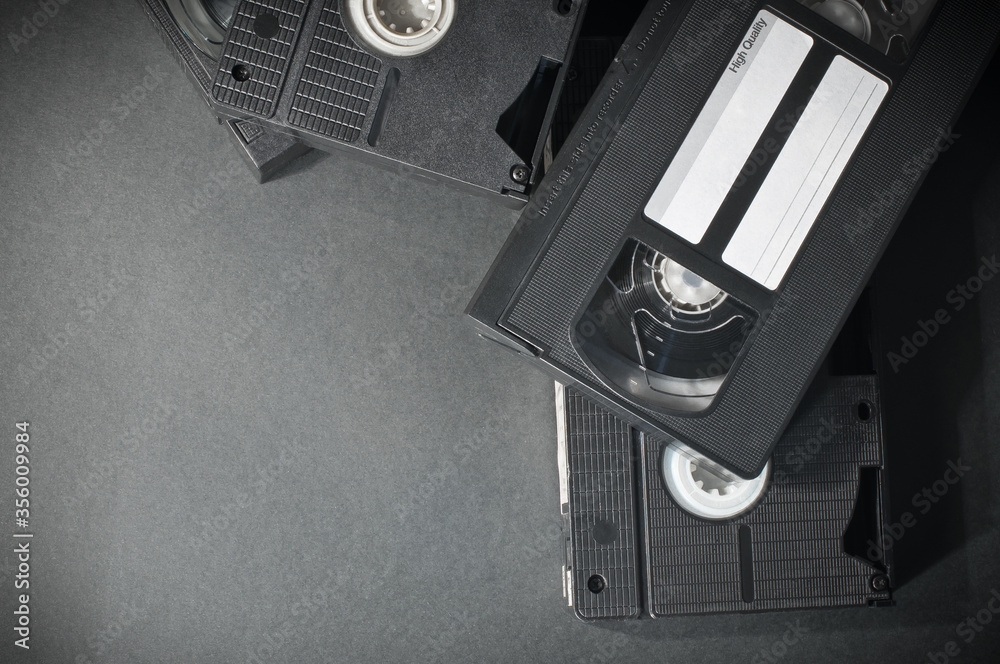 a stack of black vhs video cassettes on a black background. old film ...