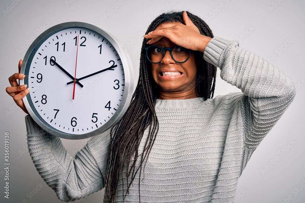 Young african american girl holding big minute clock over isolated ...