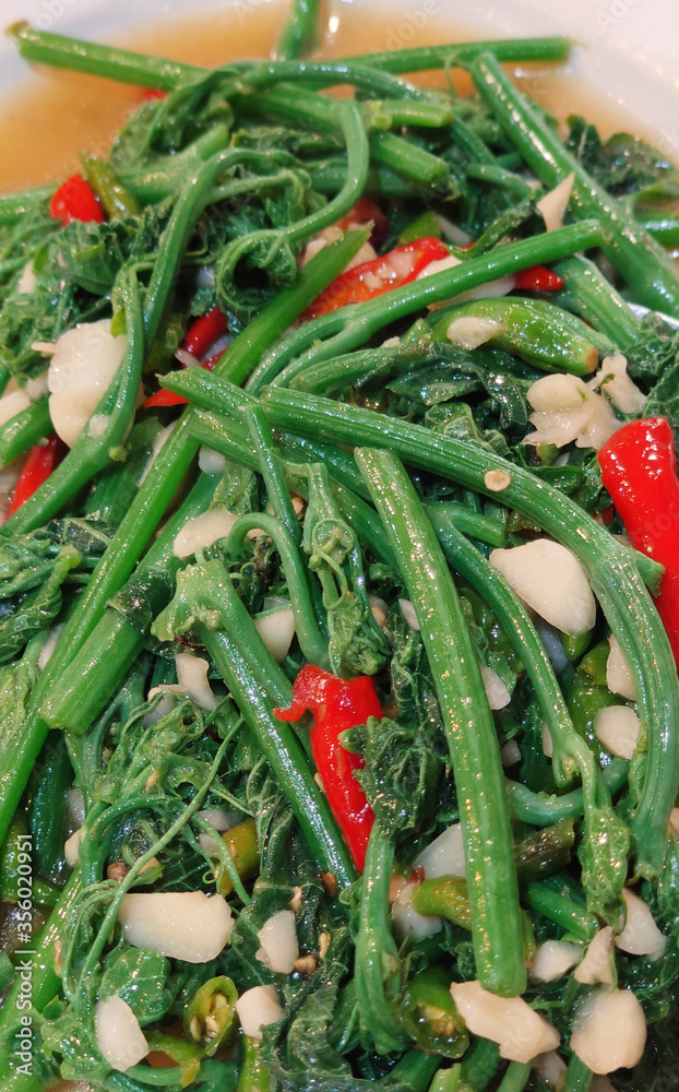 Close-up spicy juicy fried Chayote vegetable with garlic and fish ...
