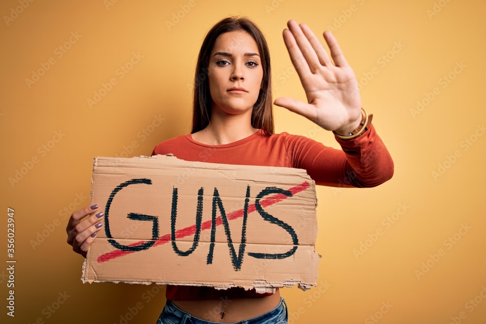 Young beautiful activist woman asking for peace holding banner with ...