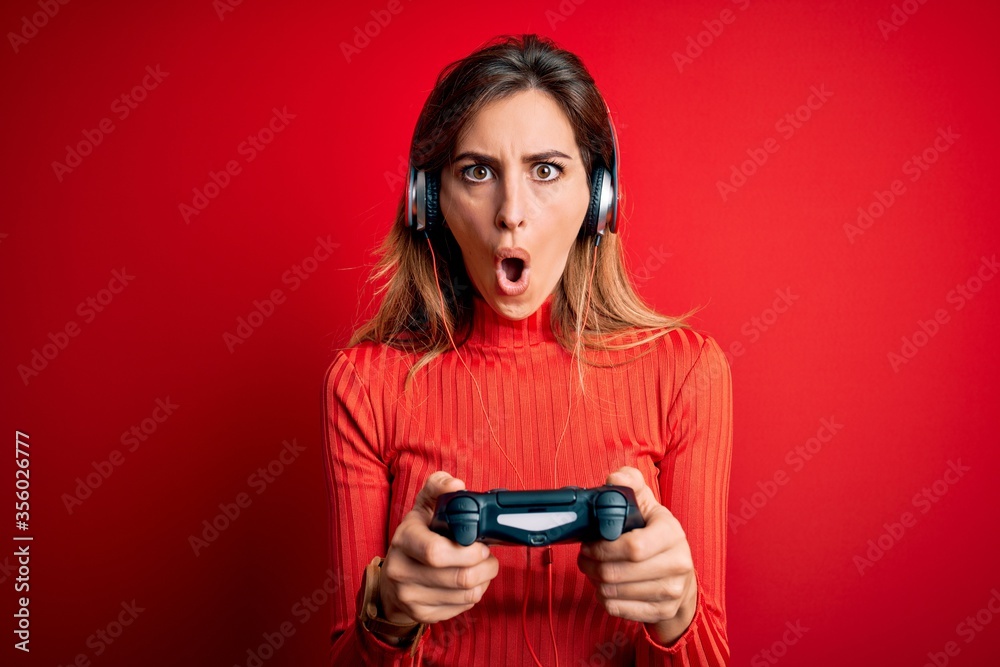 Young beautiful brunette gamer woman playing video game using joystic ...