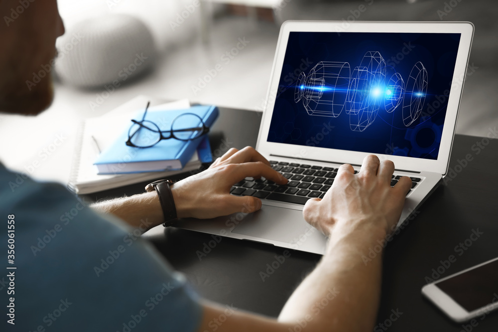 Male engineer working with 3d model of modern equipment on laptop ...