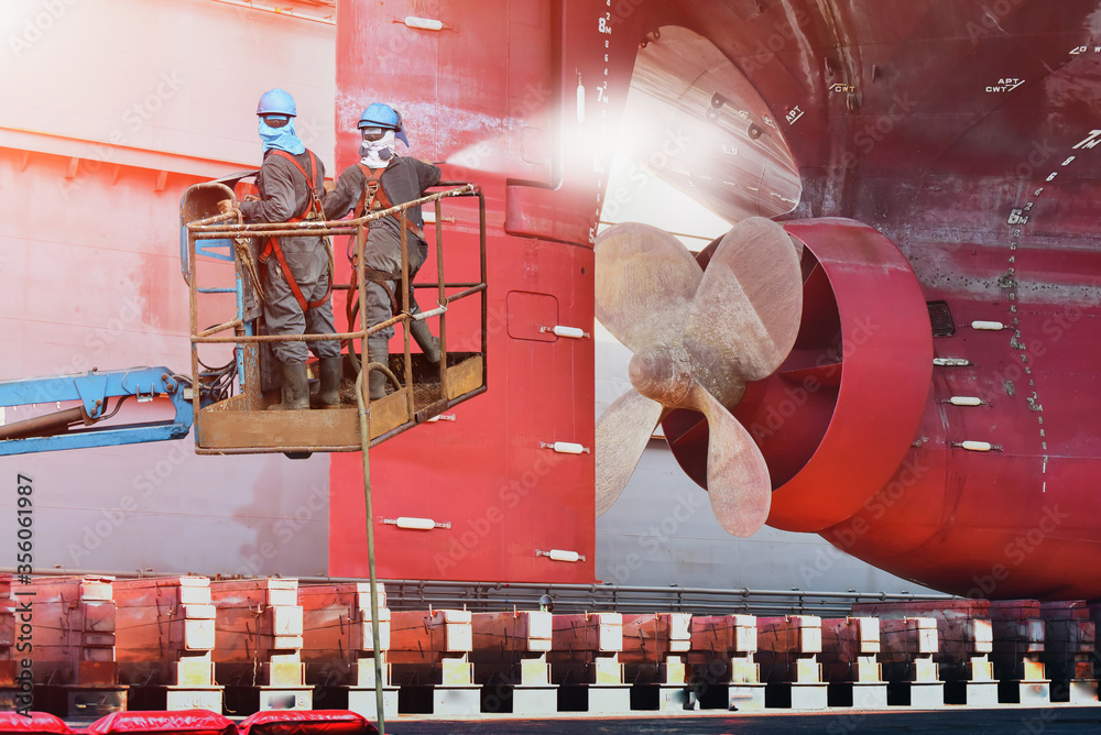 Manual ship wash with pressurized water on propeller rudder stern ship ...