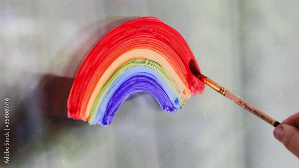 Painting rainbow on window during Covid-19. Stay at home social media ...