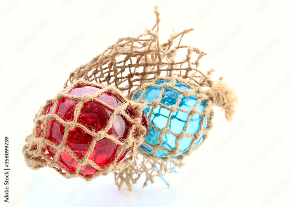 Red and blue glass net floats in traditional netting. Used to keep ...