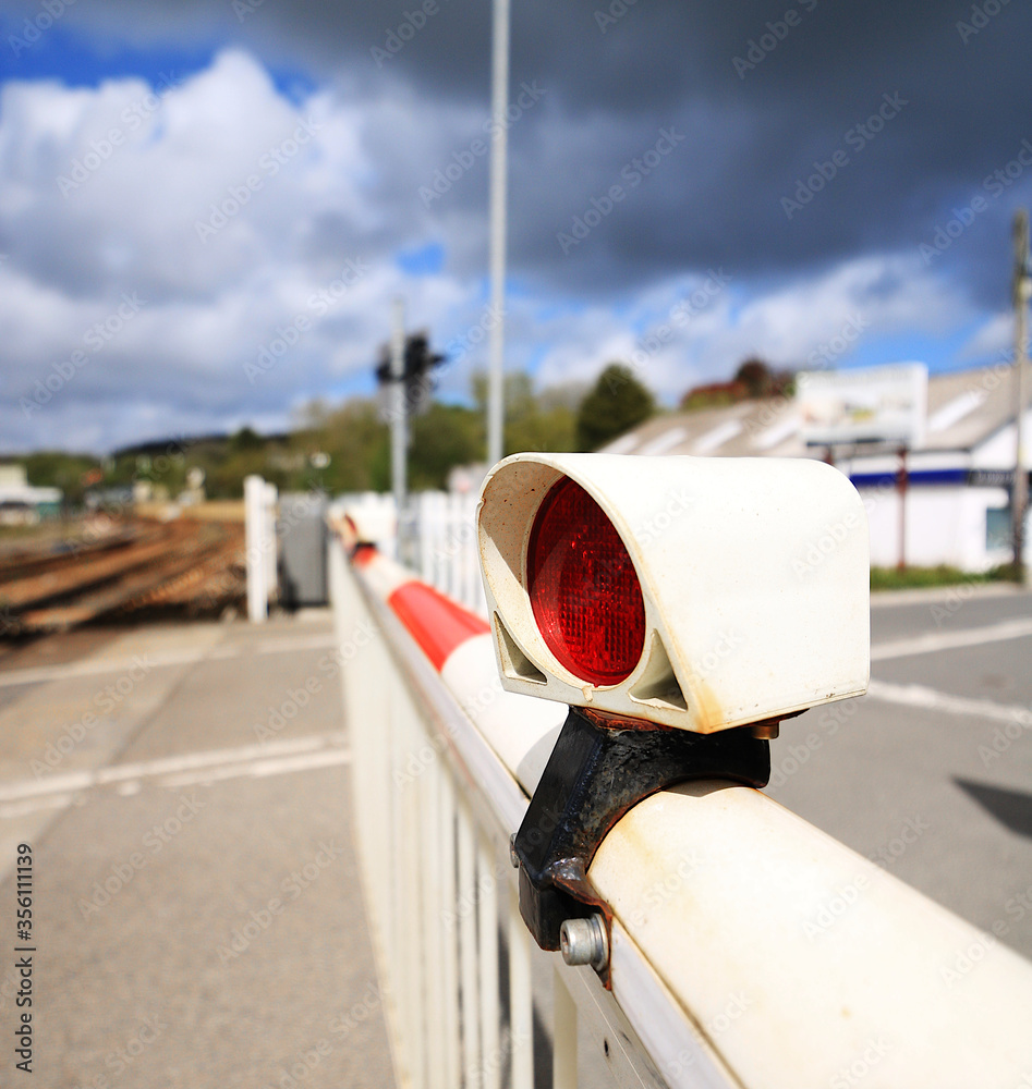 A small red illuminated sign fixed on a drop down level crossing ...
