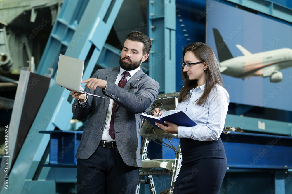 Portrait of a solid businessman with his secretary holding blue ...