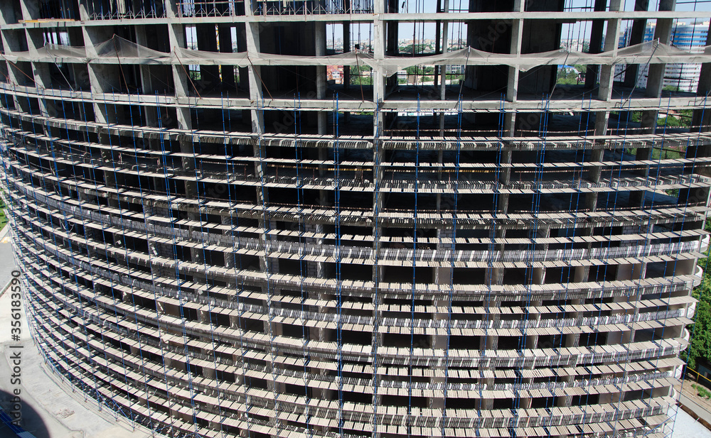 Skeleton of a monolithic multi-storey building; with scaffolding on the ...