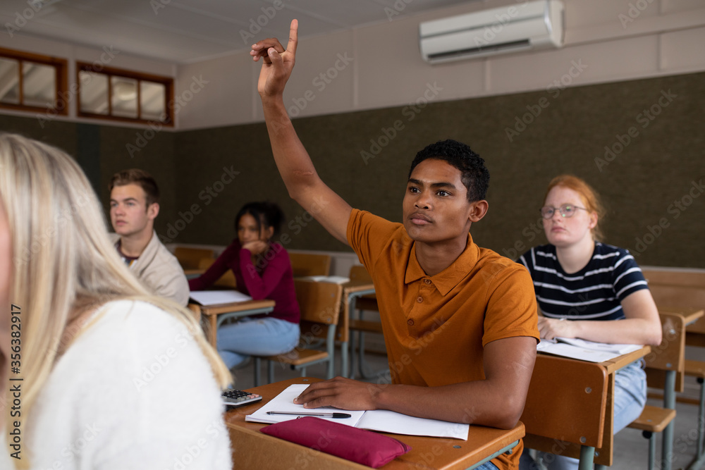 Side view of student raising his hand in class Stock Photo | Adobe Stock