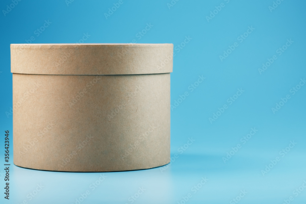 Round cardboard box on a blue background, free space. Stock Photo ...
