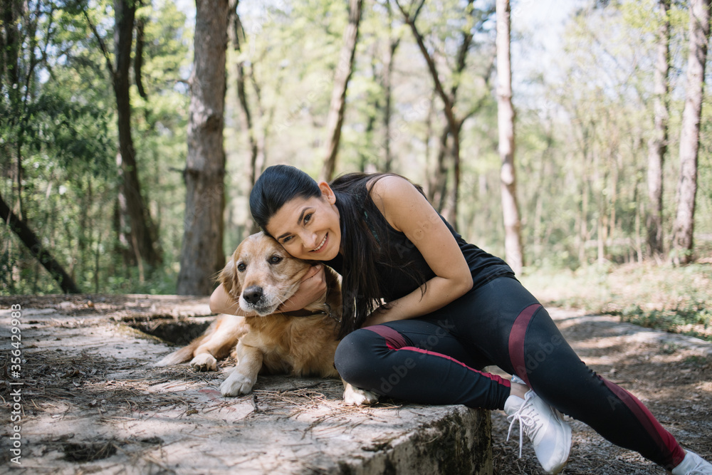 Happy woman and dog posing in nature. Smiling girl touching her head to ...