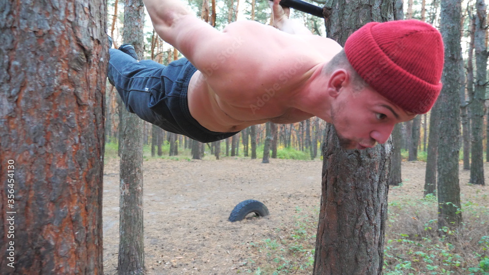 Strong man showing some gymnastics stunts on horizontal bar. Muscular ...