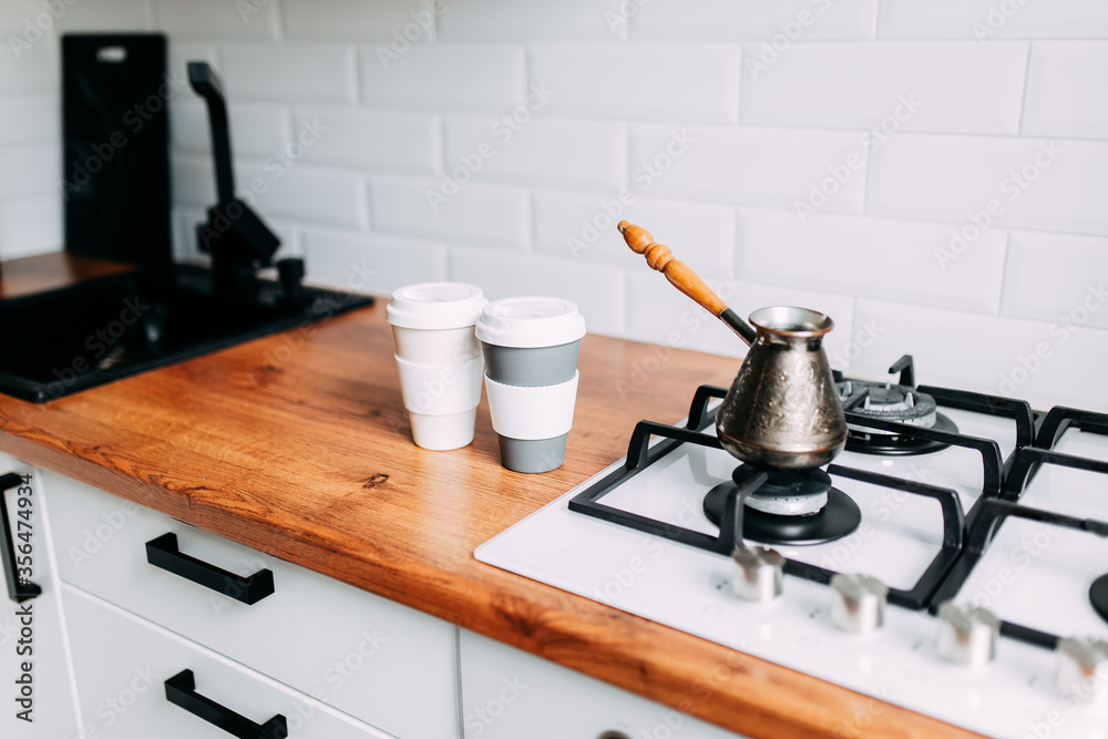Coffee brewing at home in jezve on gas oven. Coffee cups to go on the ...