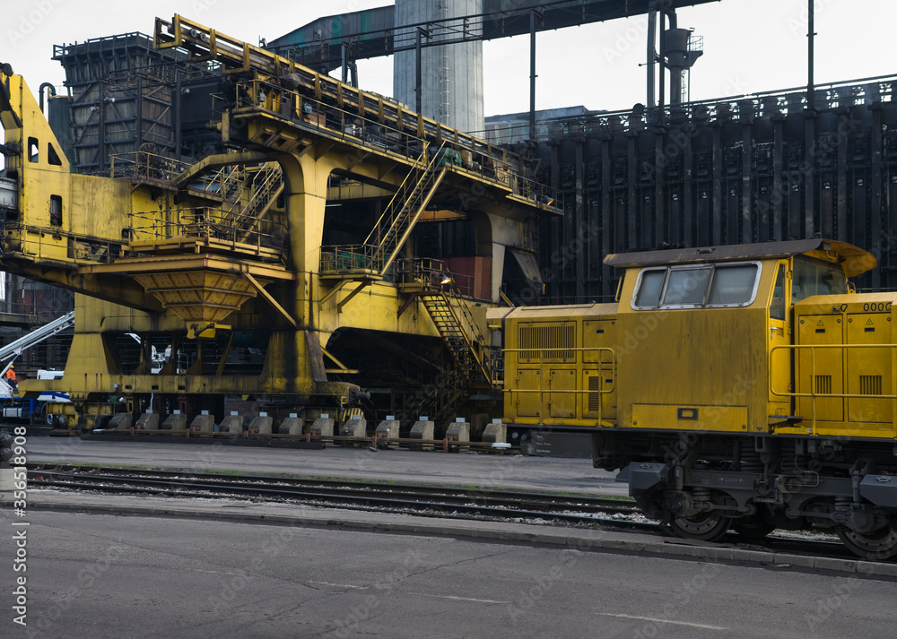 From below of pusher machine and electric locomotive on plant ...