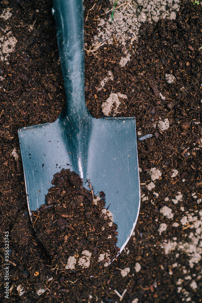 From above of metal garden shovel with soil digging ground in sunny ...