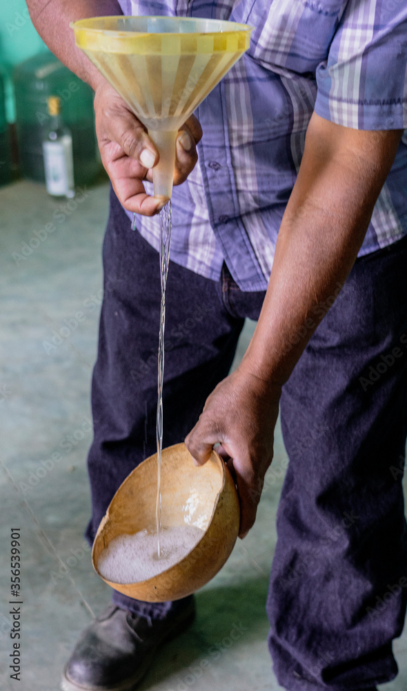 Mezcal is poured through a funnel to study the bubbles and determine ...