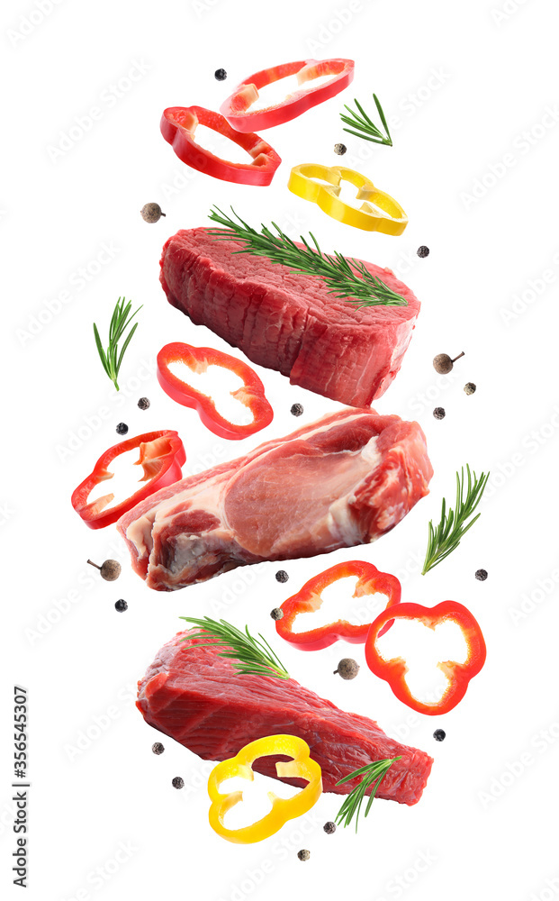 Raw beef meat and other ingredients falling on white background Stock ...