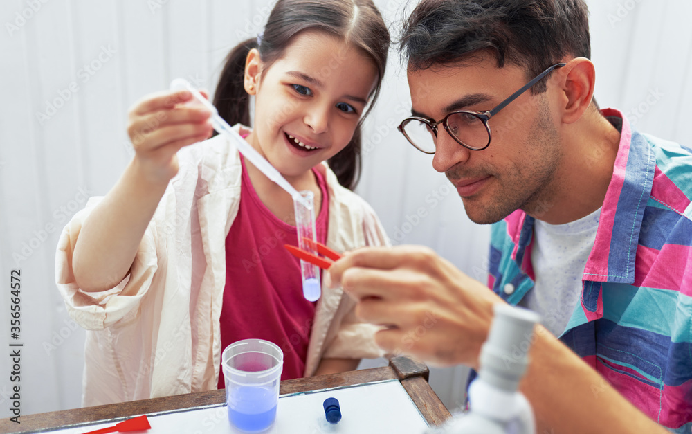 Little girl and her father doing science experiments in the laboratory ...