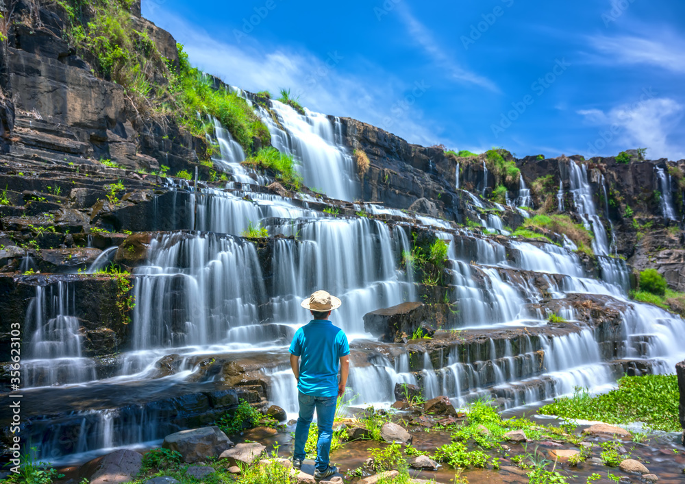 Traveler Man enjoying beautiful waterfall majestic scenery as a way to ...