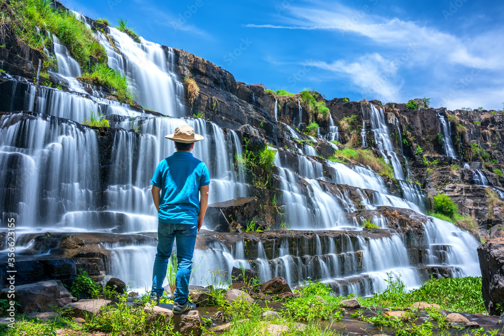 Traveler Man enjoying beautiful waterfall majestic scenery as a way to ...