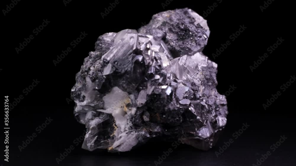 Shiny rock with cerussite crystals slowly rotating over a black ...