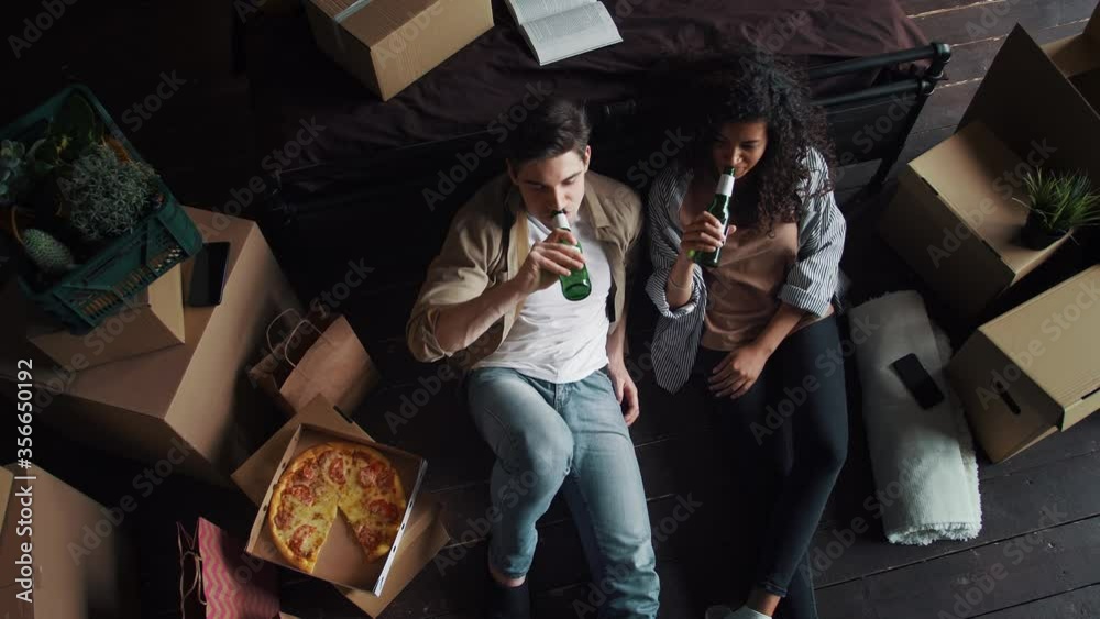 Guy and girl relocating to a new house. Smiling and talking, enjoying ...