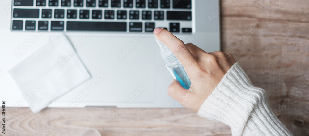 Woman cleaning laptop by wet wipes tissue and alcohol disinfectant on ...