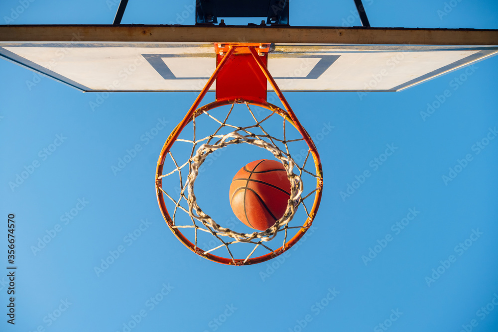 Street basketball ball falling into the hoop. Urban youth game. Close ...