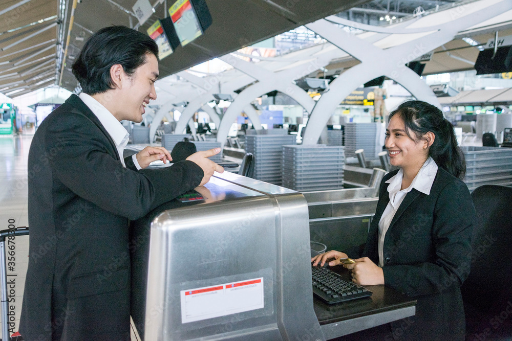 Business man standing at an airport counter checking in boarding pass ...