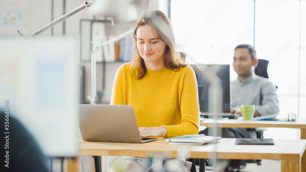 Beautiful and Creative Young Woman Sitting at Her Desk Using Laptop ...