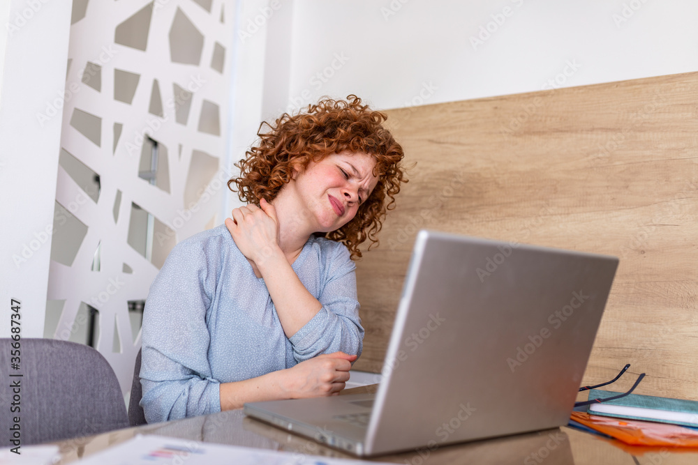 Businesswoman feeling pain in neck after sitting at the table with ...