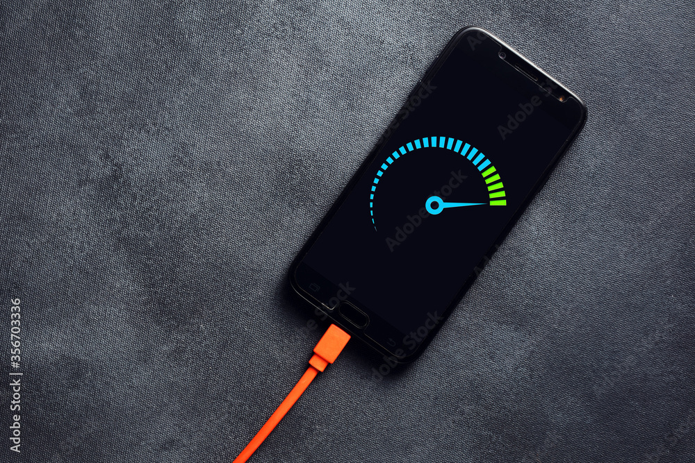 Smartphone connected to a usb charging cable and fast charging on black ...