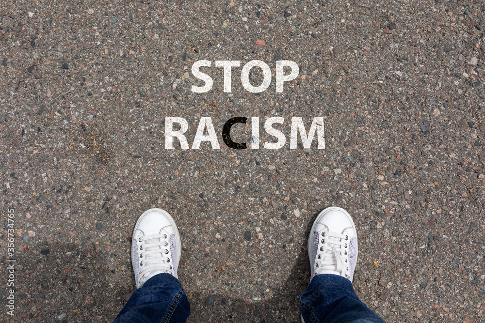 eet of a Man standing on a dark road with the text "stop racism". The ...