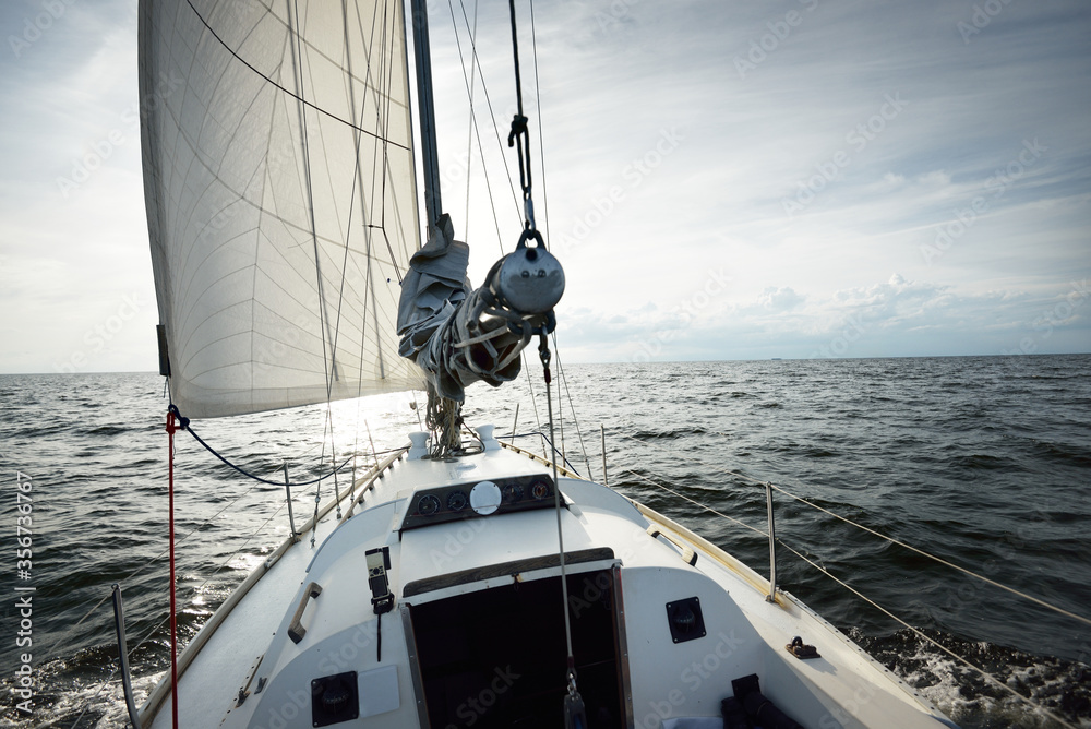 Blue yacht sailing in an open sea on a sunny summer day. Top down view ...