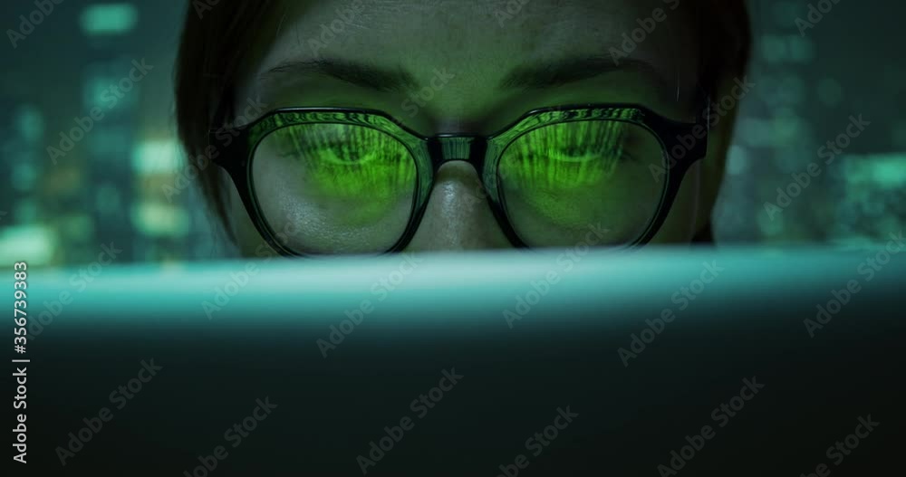 Woman programmer hacker in glasses is working on computer in cyber ...