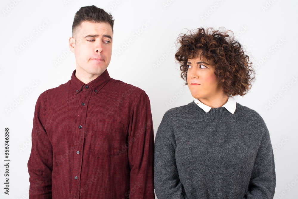 Photo of amazed puzzled young Caucasian man and woman, curves lips and ...
