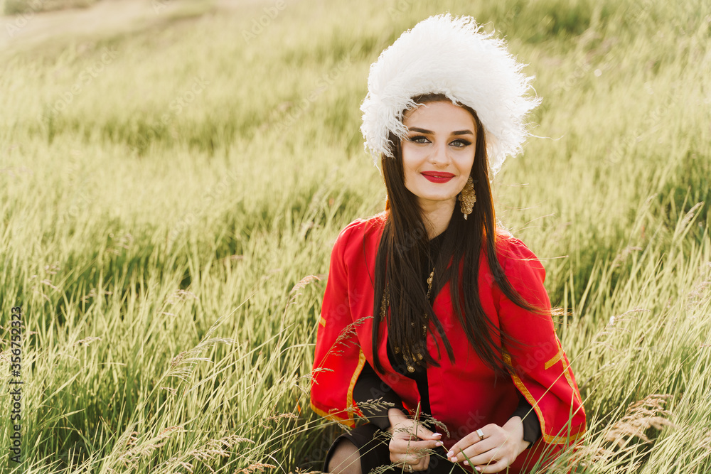 Georgian girl in white papakha and red national dress seats on the ...