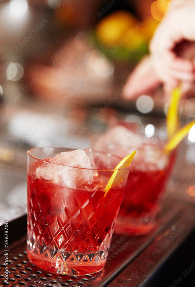 Colorful cocktails being prepared and lined up on the bar with a lemon ...