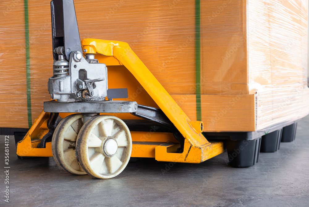 Hand pallet truck with heavy shipment pallet. Stock Photo | Adobe Stock