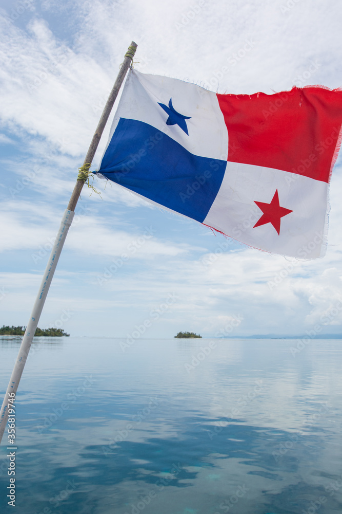 Panamanian Flag waving on a pvc wooden pole with blue sea in background ...