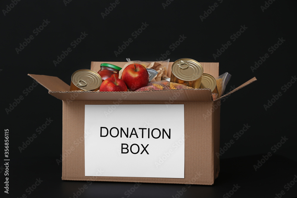Donation box with products on dark background Stock Photo | Adobe Stock